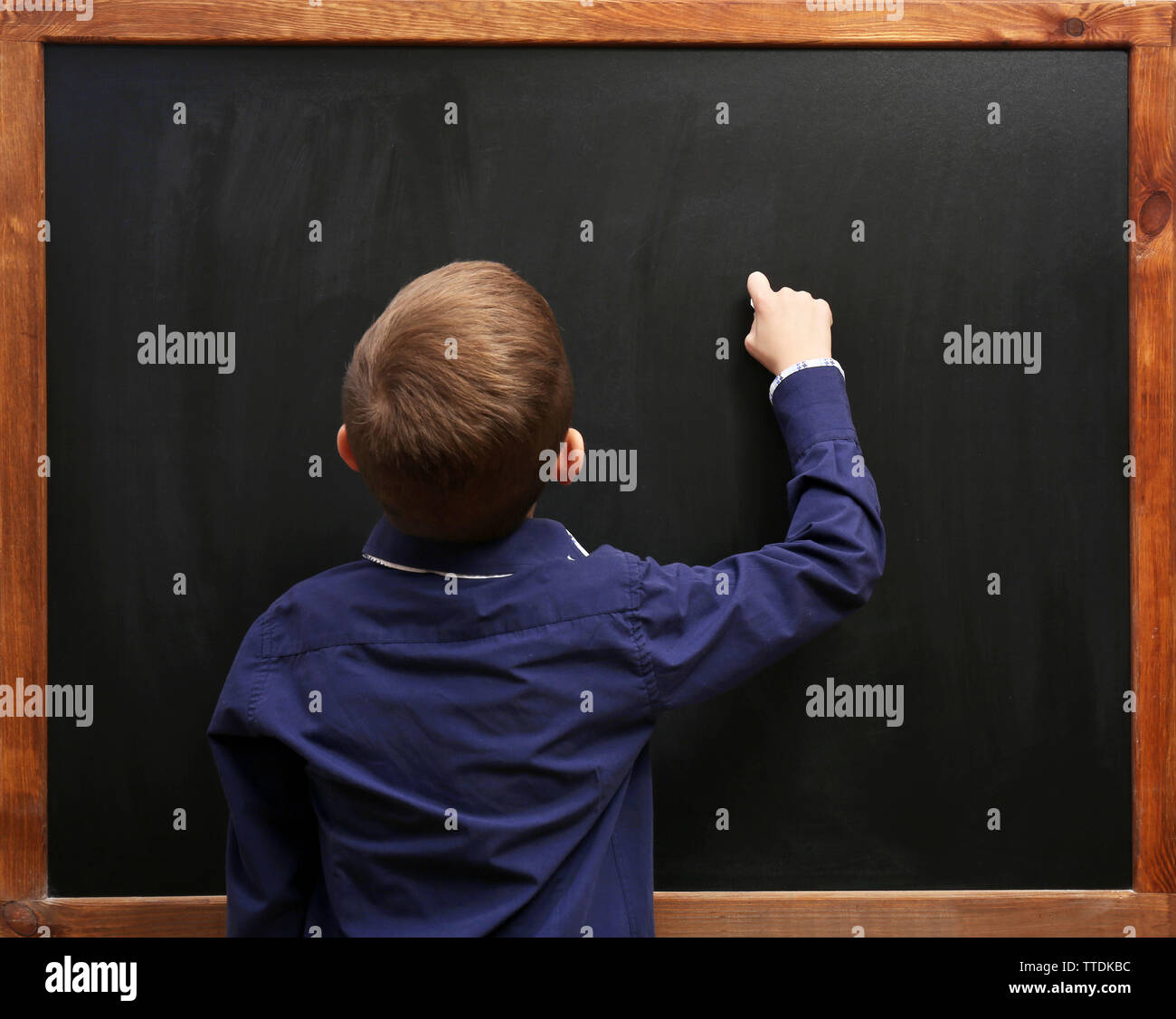 Back view of a boy posing at the blackboard, in the classroom Stock ...