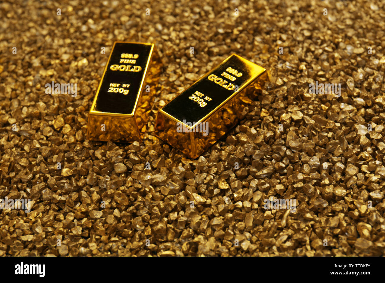 Gold bars on nugget grains background, close-up Stock Photo - Alamy