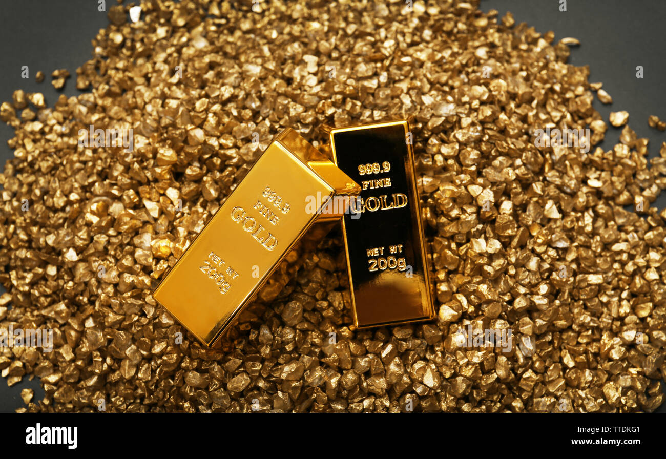 Gold bars on nugget grains background, close-up Stock Photo - Alamy