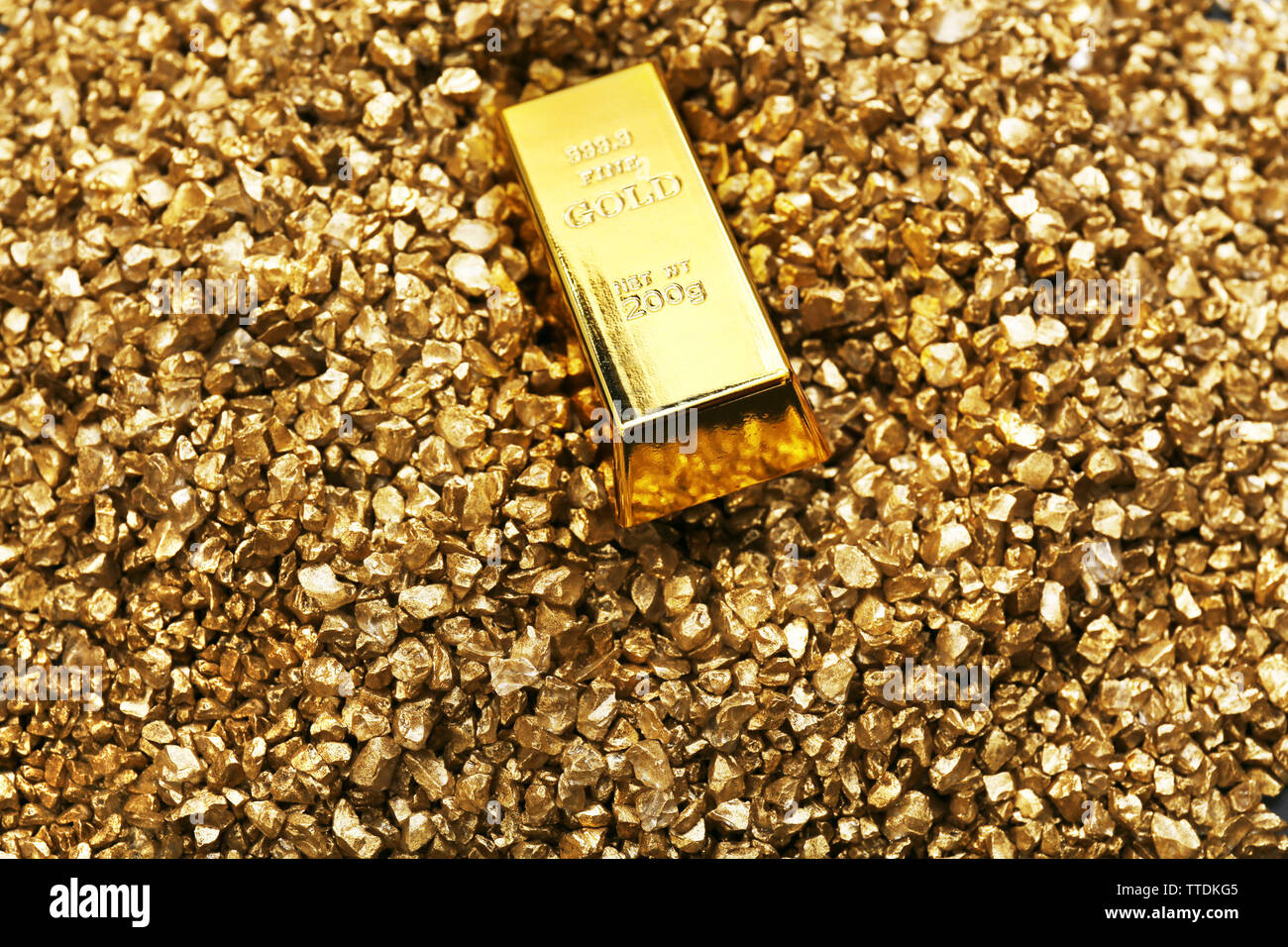 Gold bars on nugget grains background, close-up Stock Photo - Alamy