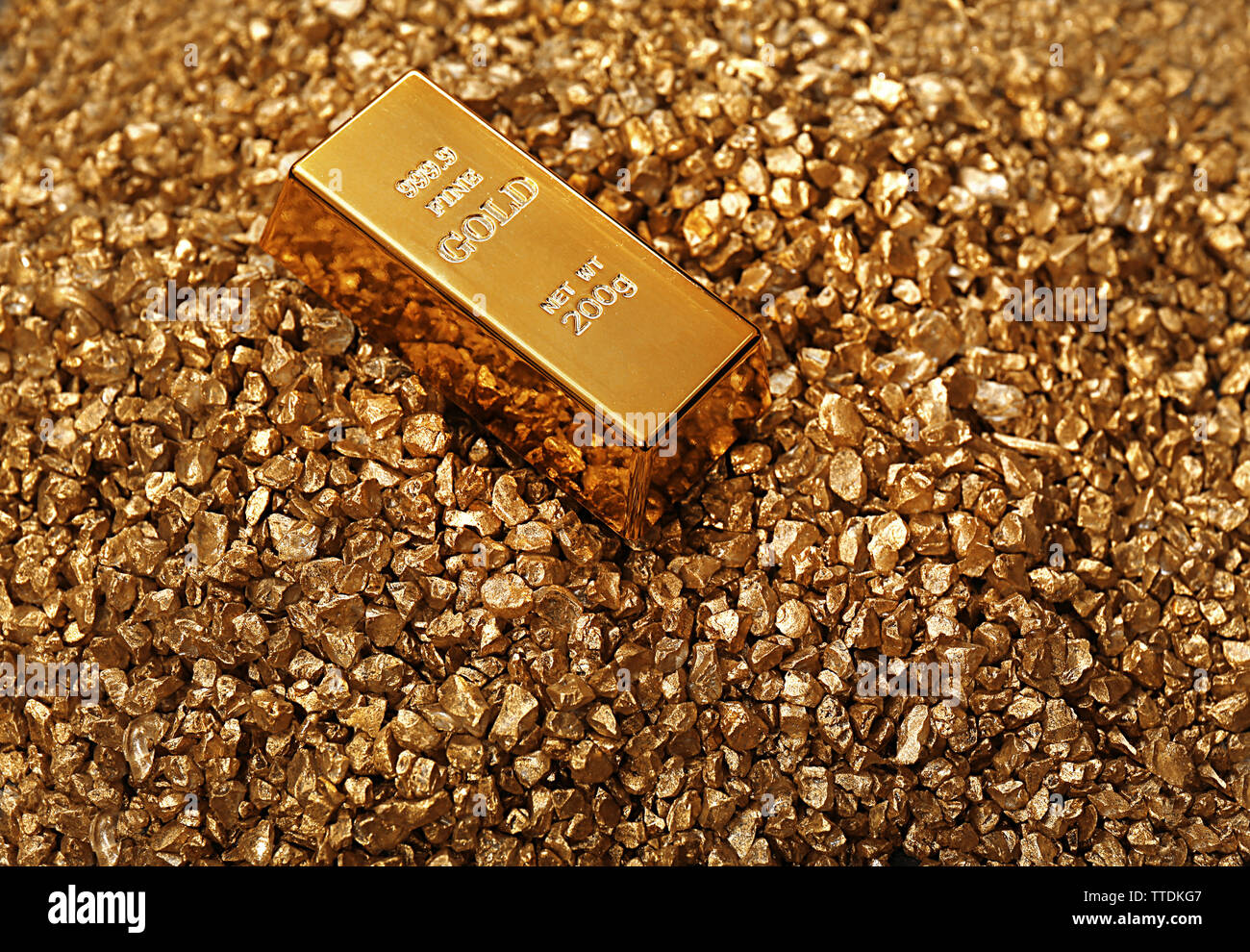 Gold bars on nugget grains background, close-up Stock Photo - Alamy