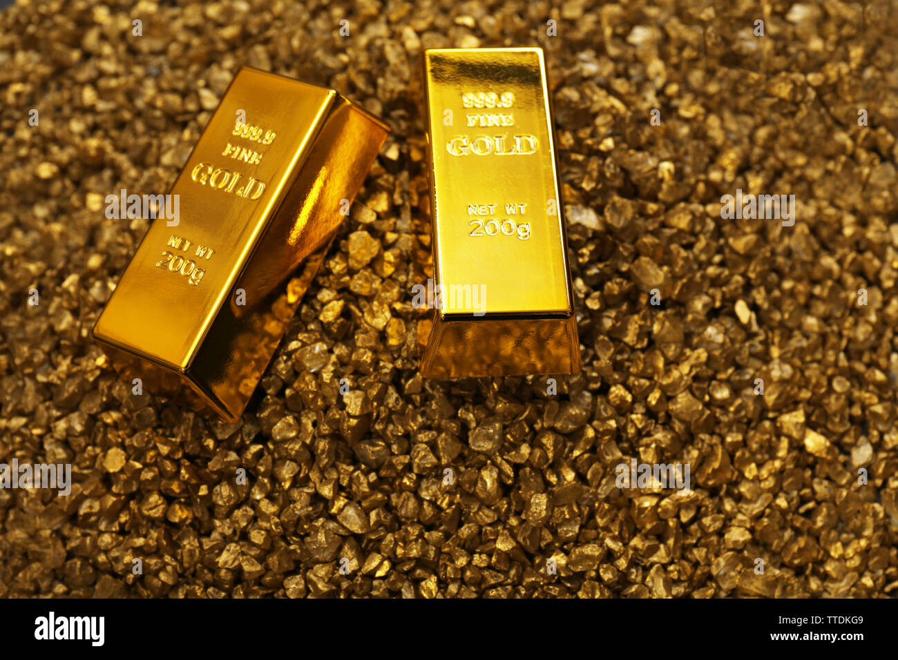 Gold bars on nugget grains background, close-up Stock Photo - Alamy