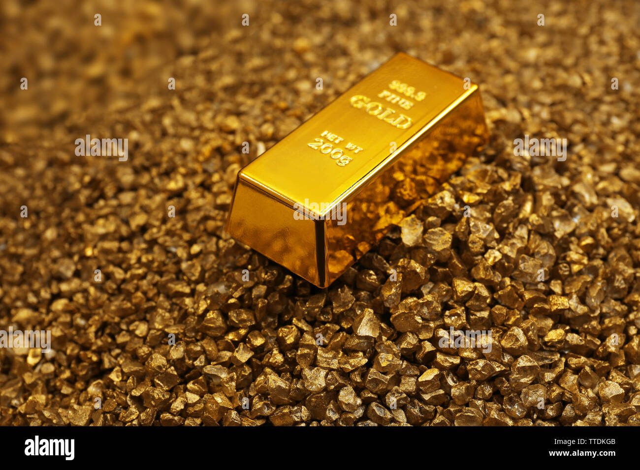 Gold bars on nugget grains background, close-up Stock Photo - Alamy
