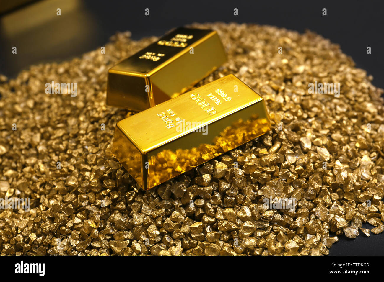 Gold bars on nugget grains background, close-up Stock Photo - Alamy