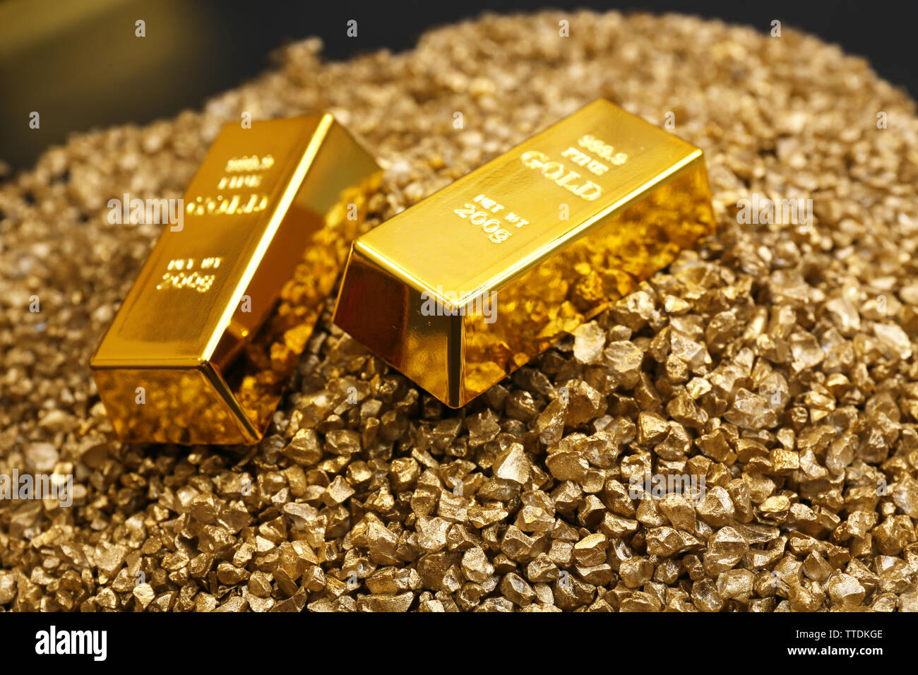 Gold bars on nugget grains background, close-up Stock Photo - Alamy