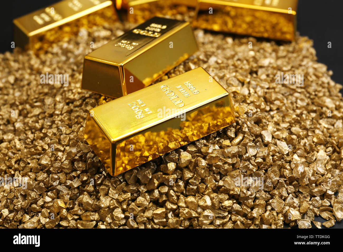 Gold bars on nugget grains background, close-up Stock Photo - Alamy