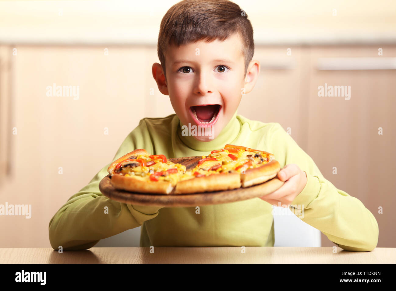 Little boy eating pizza at home Stock Photo - Alamy