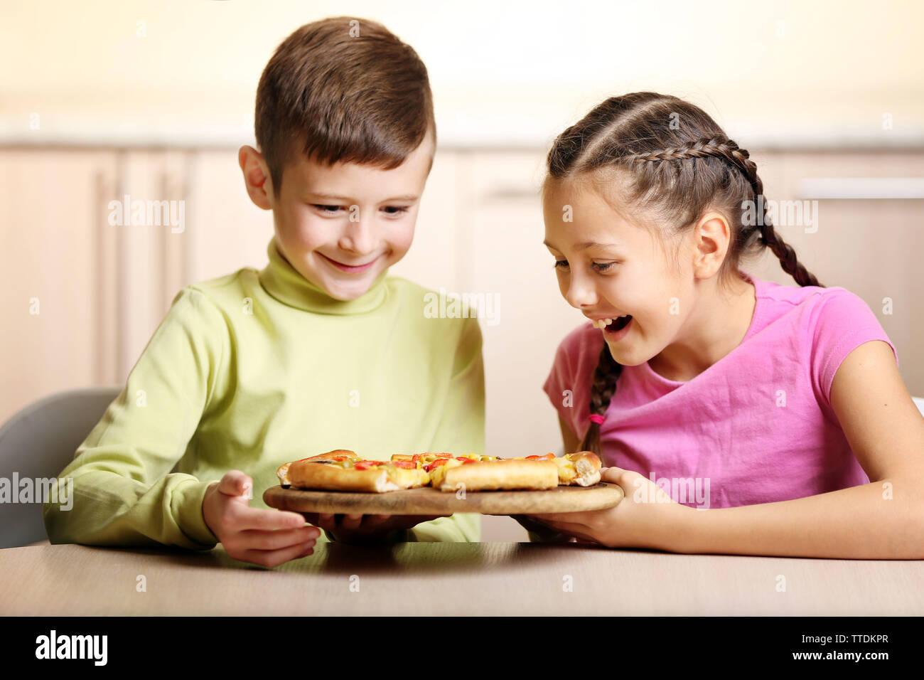 Children eating pizza at home Stock Photo - Alamy