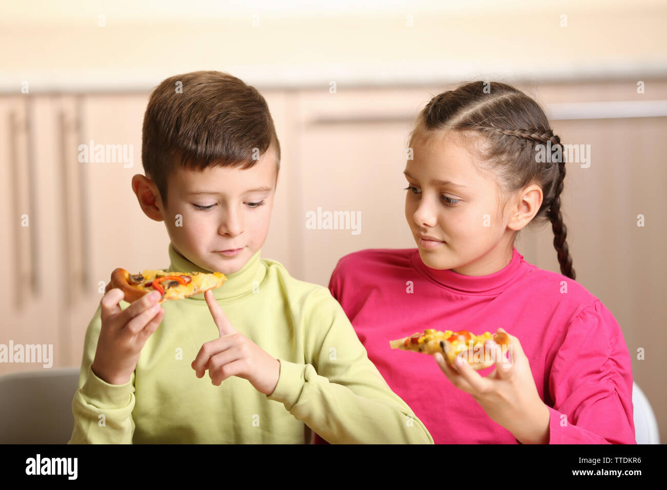 Children eating pizza at home Stock Photo - Alamy
