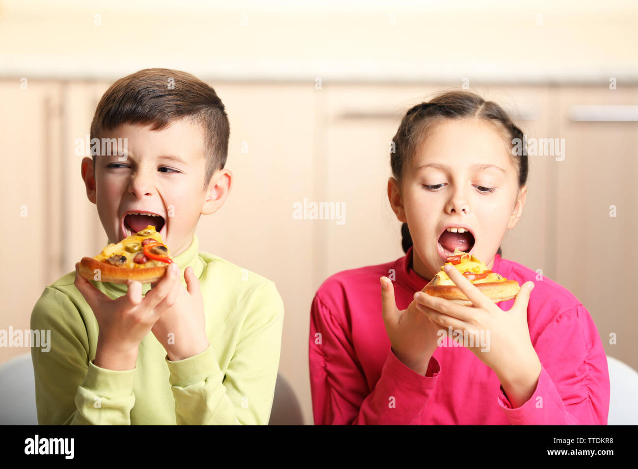 Children eating pizza at home Stock Photo - Alamy