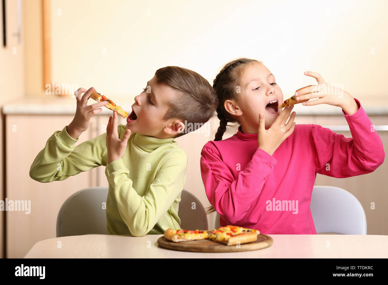 Children eating pizza at home Stock Photo - Alamy