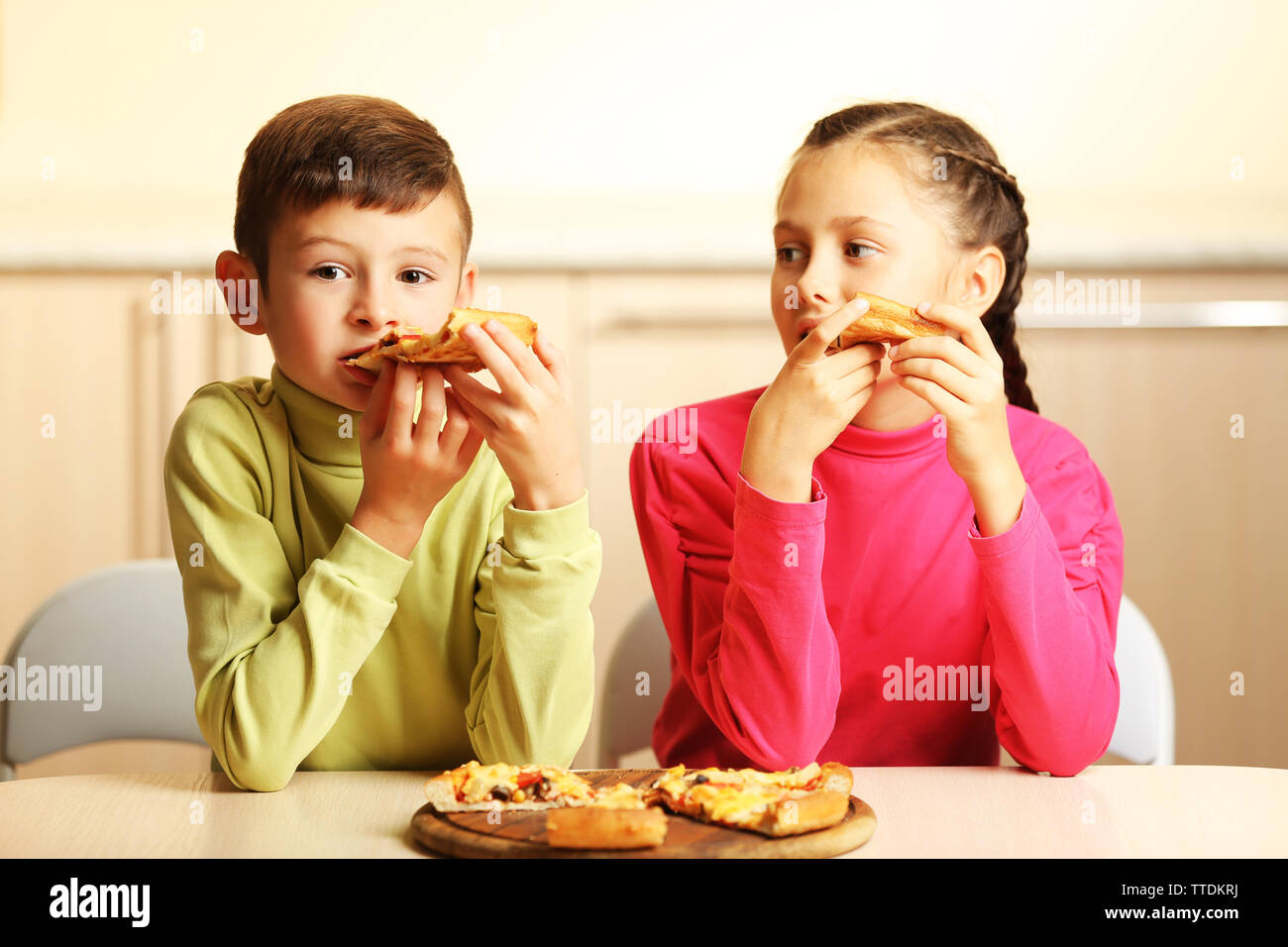 Children eating pizza at home Stock Photo - Alamy