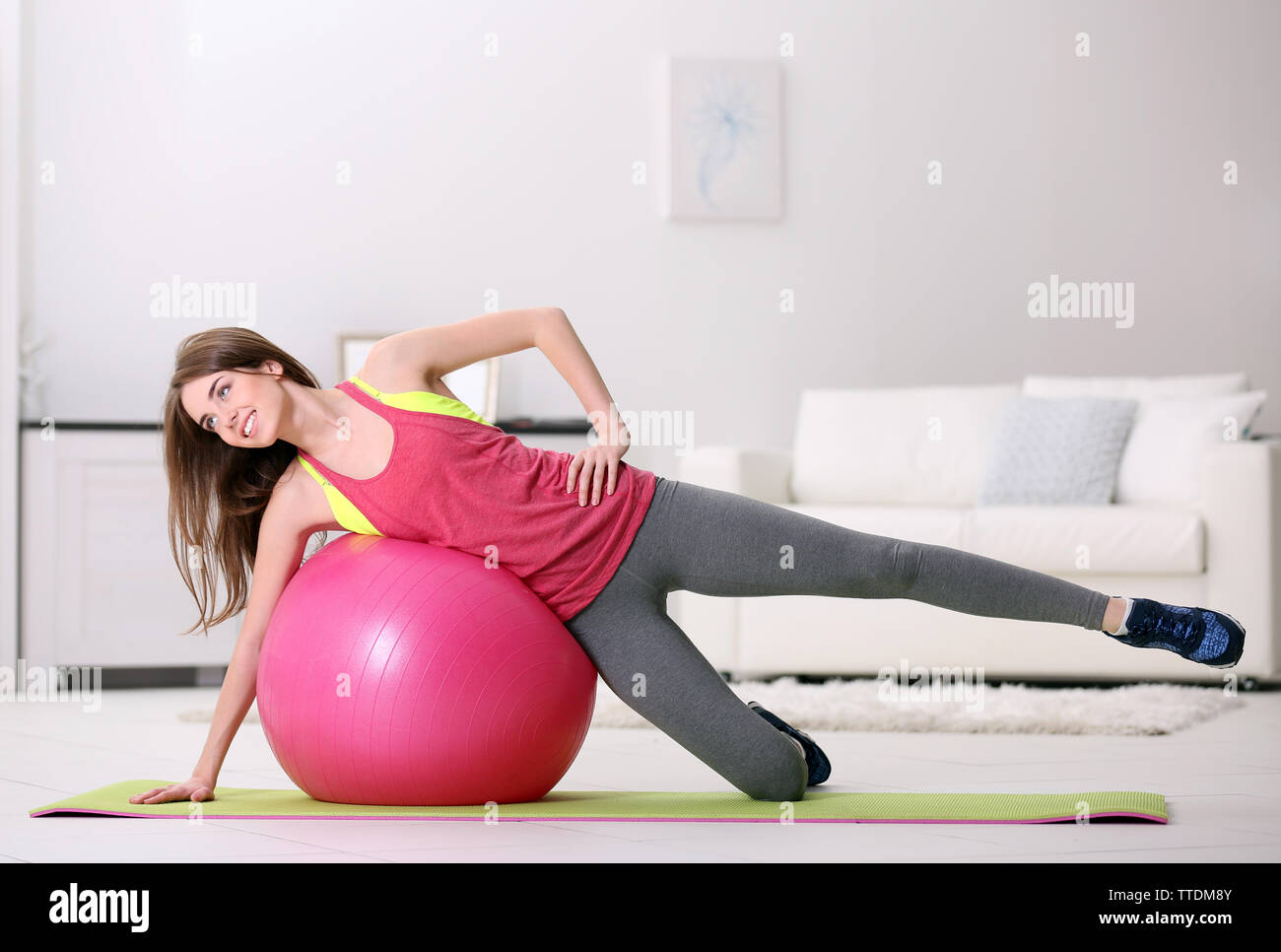 Beautiful young girl doing exercises with fit ball at home Stock Photo ...