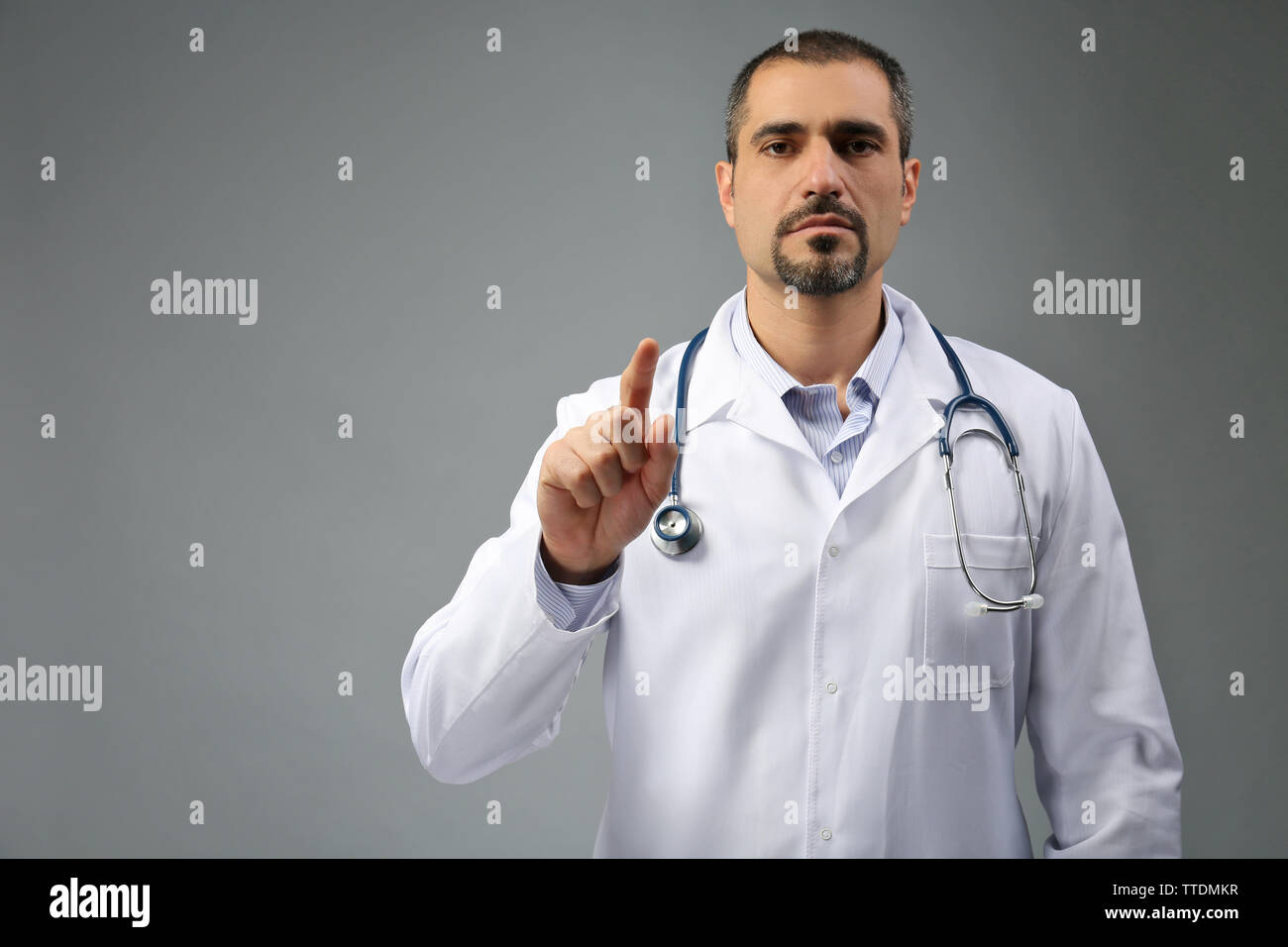 Portrait of a doctor with stethoscope on grey background Stock Photo ...