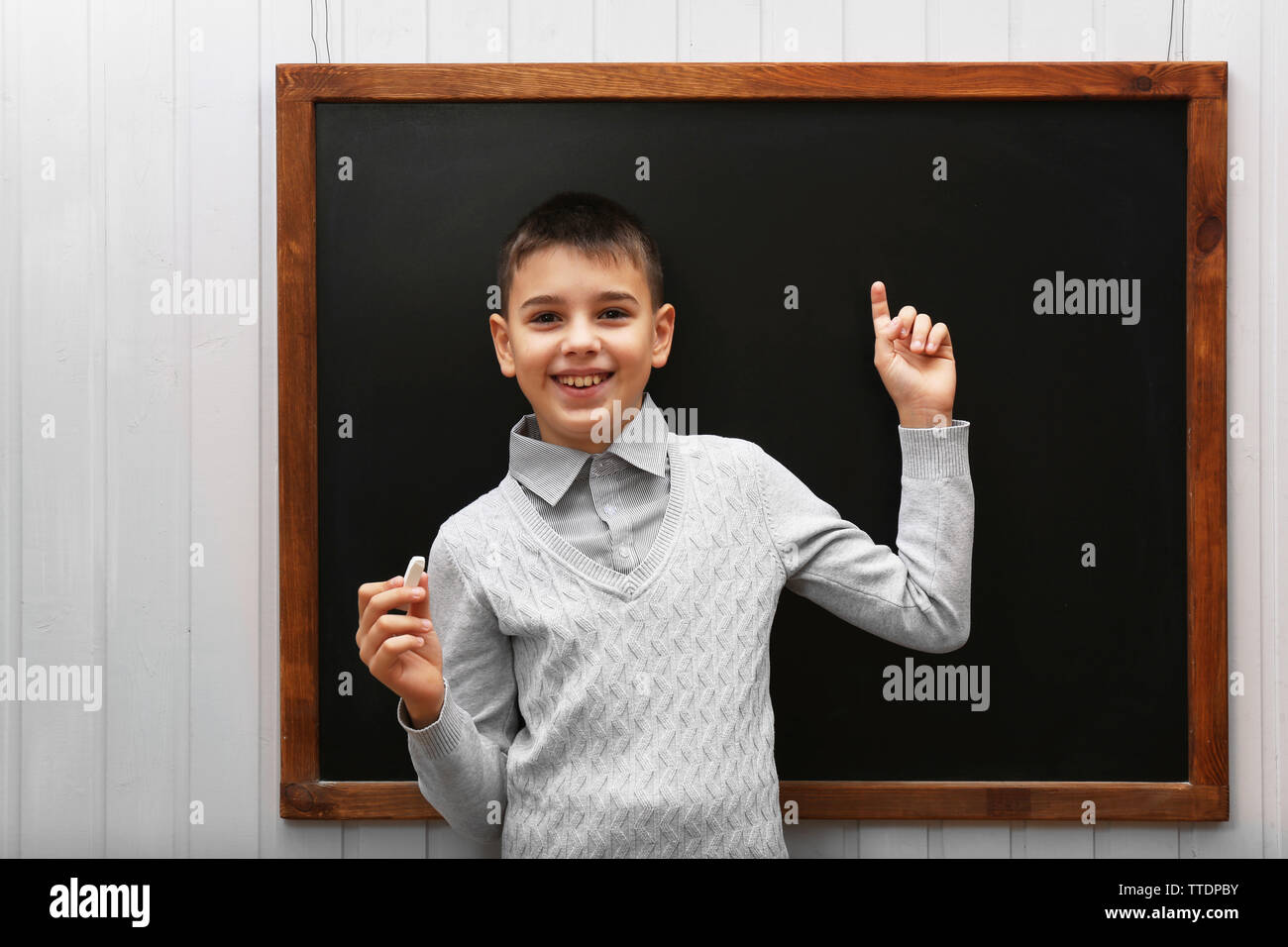 Young cute schoolboy standing at the blackboard Stock Photo - Alamy