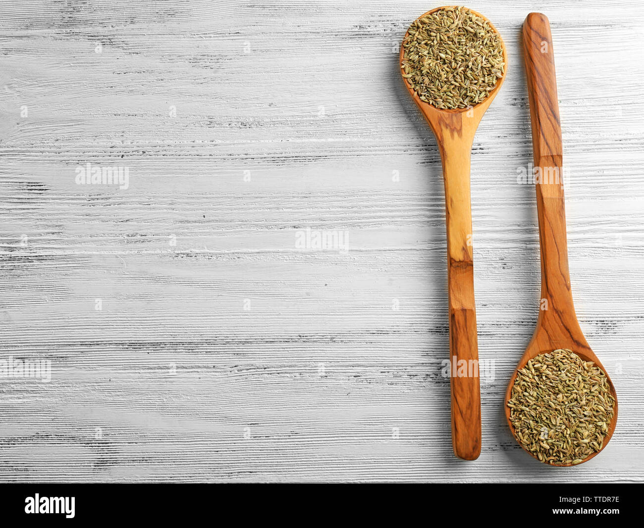 Two wooden spoons with cumin on the table, close-up Stock Photo - Alamy