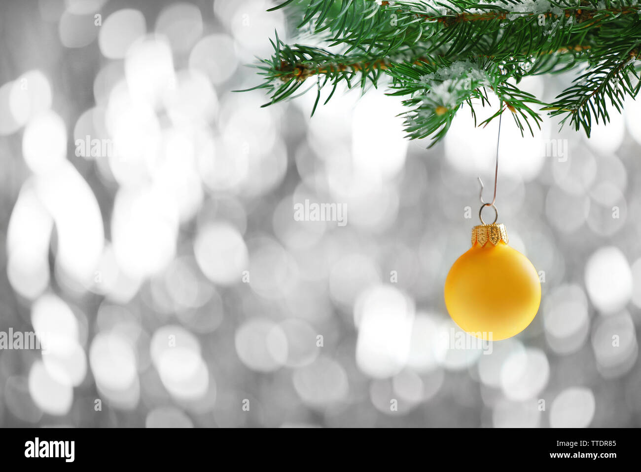 Christmas yellow bauble on a fir branch and glitter background Stock ...