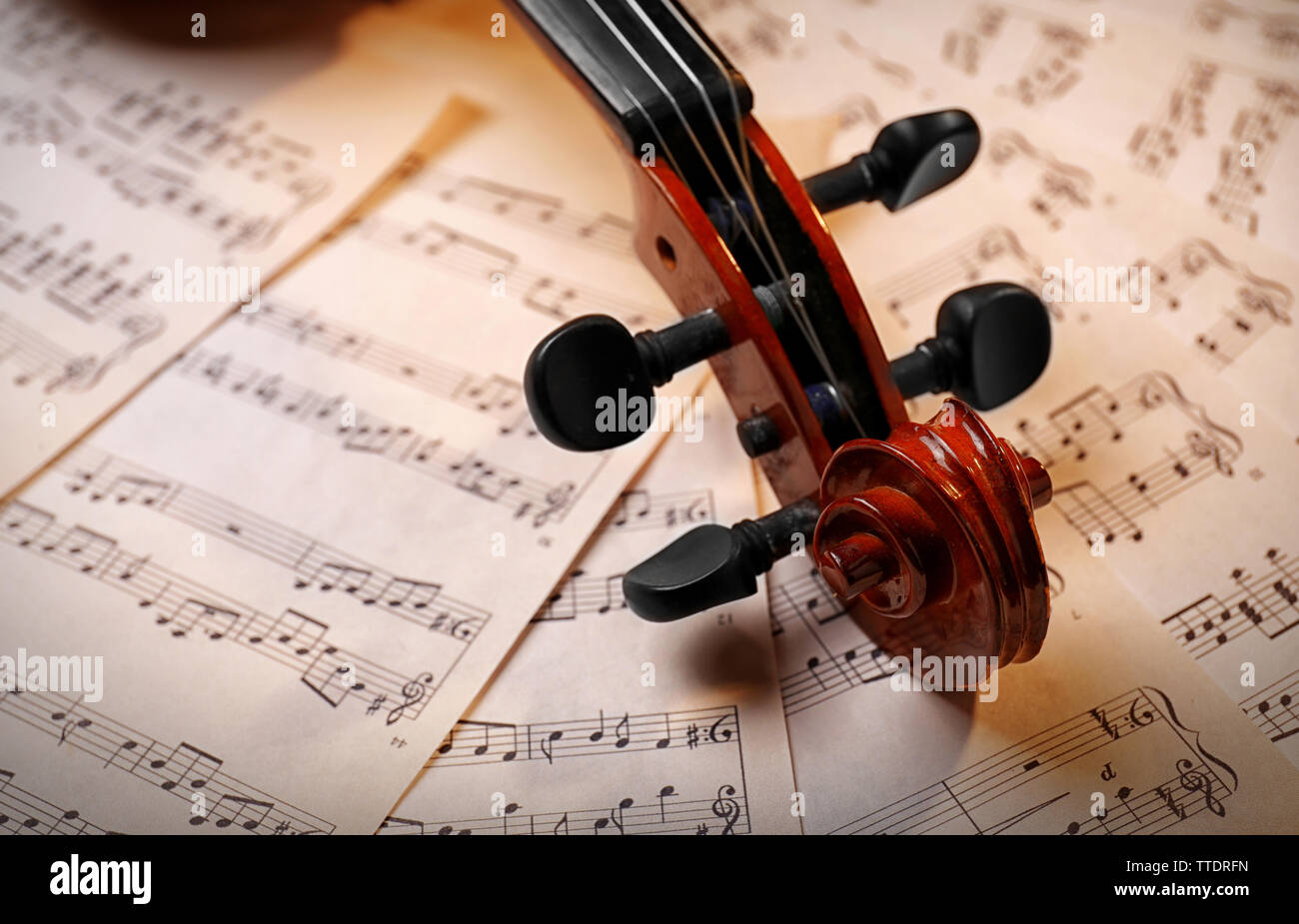 Violin neck on music papers background Stock Photo - Alamy