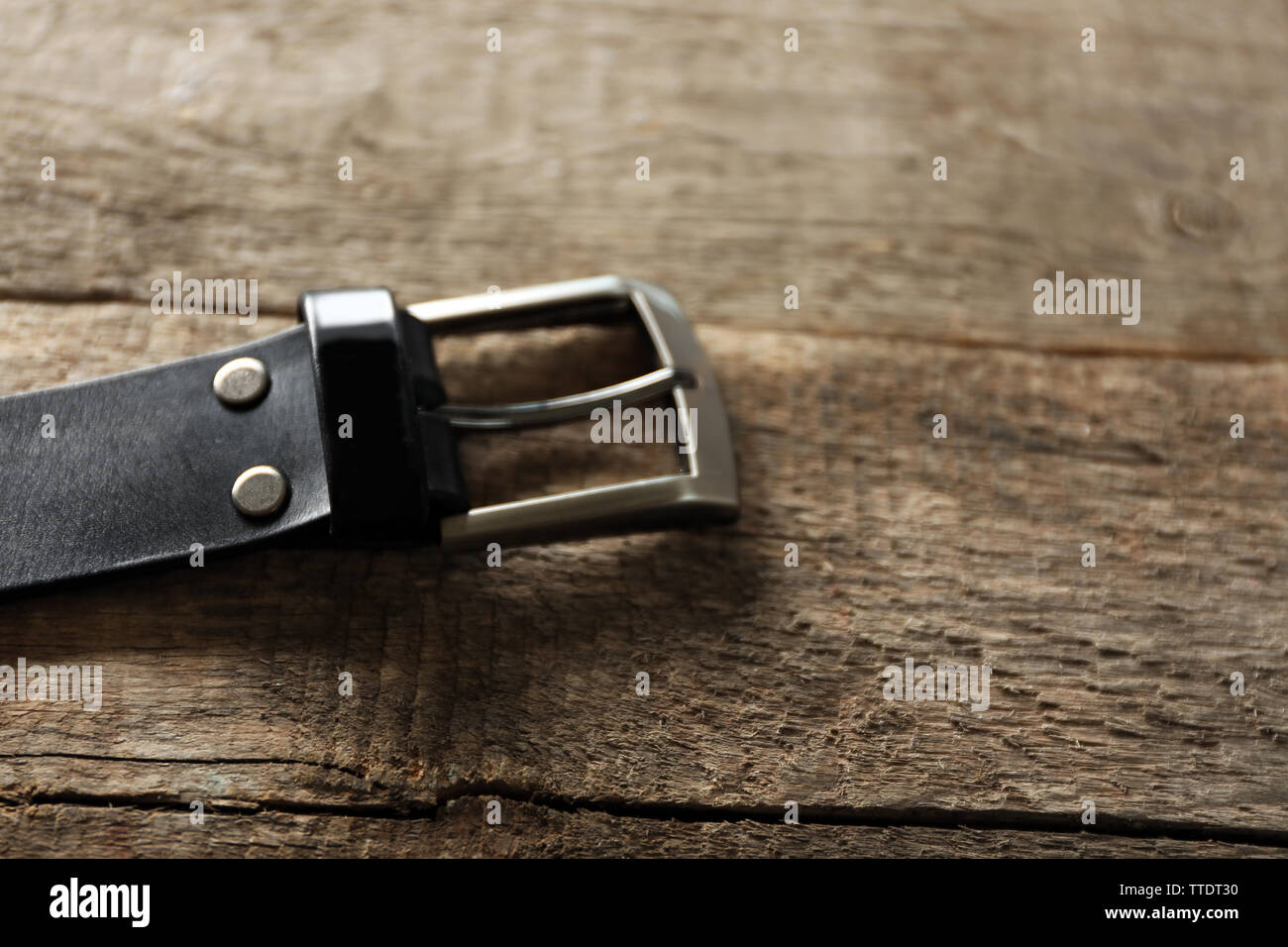 Leather belt with buckle on wooden background Stock Photo - Alamy