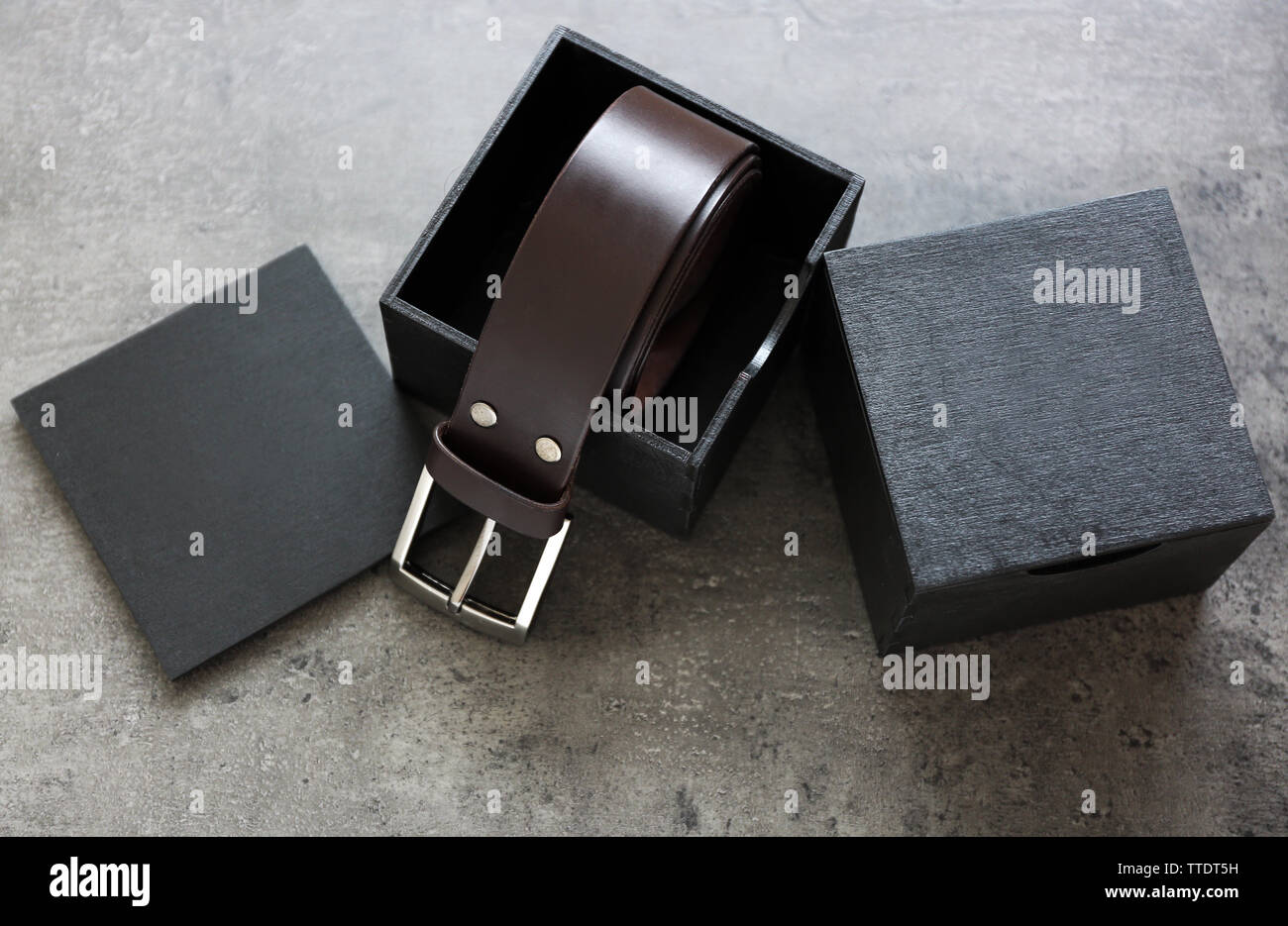 Leather belt with buckle and gift box on gray background Stock Photo ...