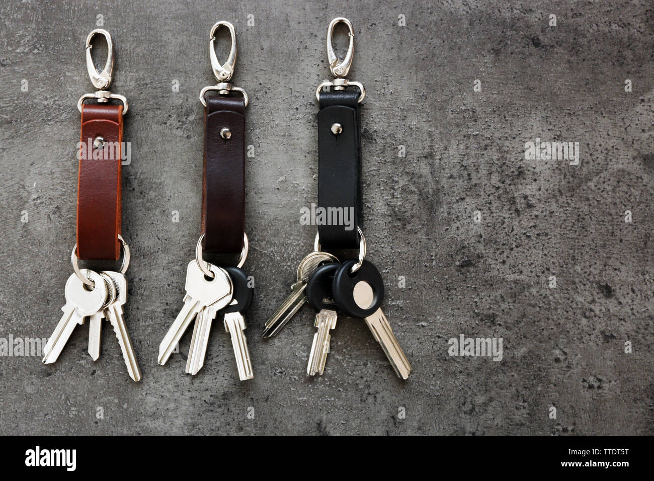 Keys attached to leather keychain , on gray background Stock Photo - Alamy