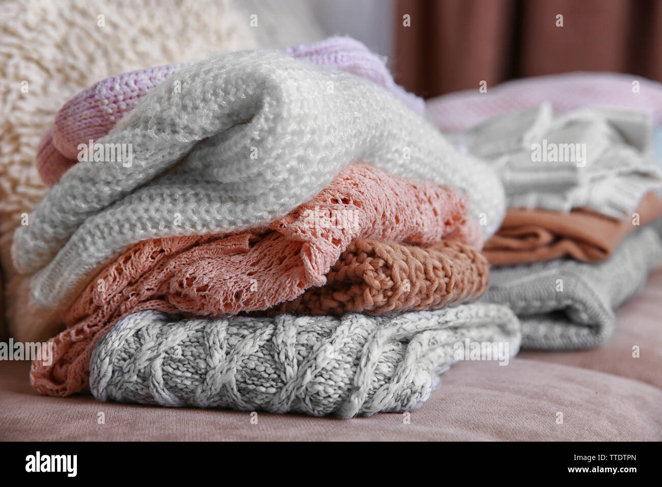 Knitted clothes on a sofa Stock Photo - Alamy