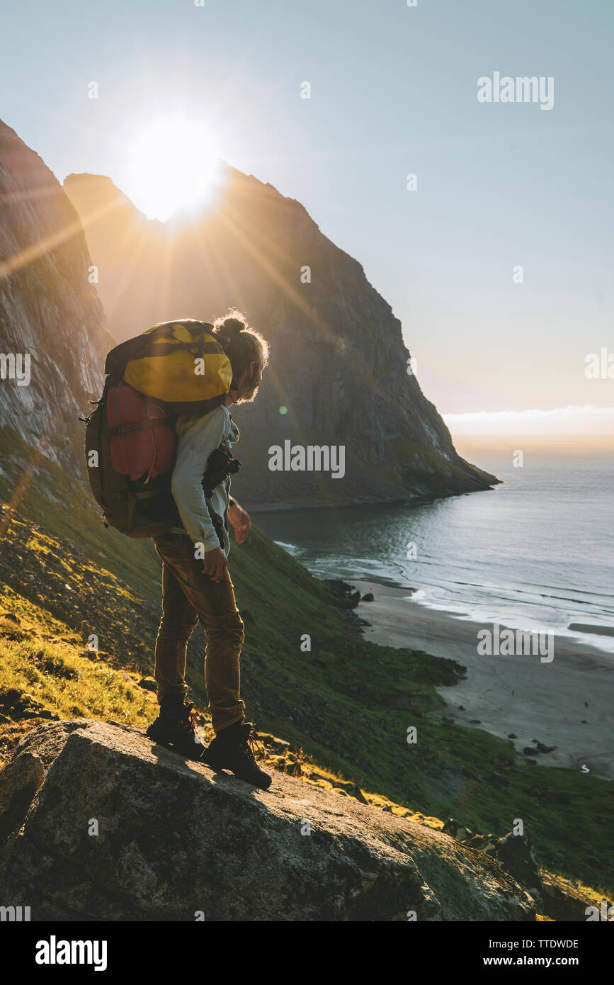 Man mountaineer standing on rock of peak mountain at sunset. Ryten ...