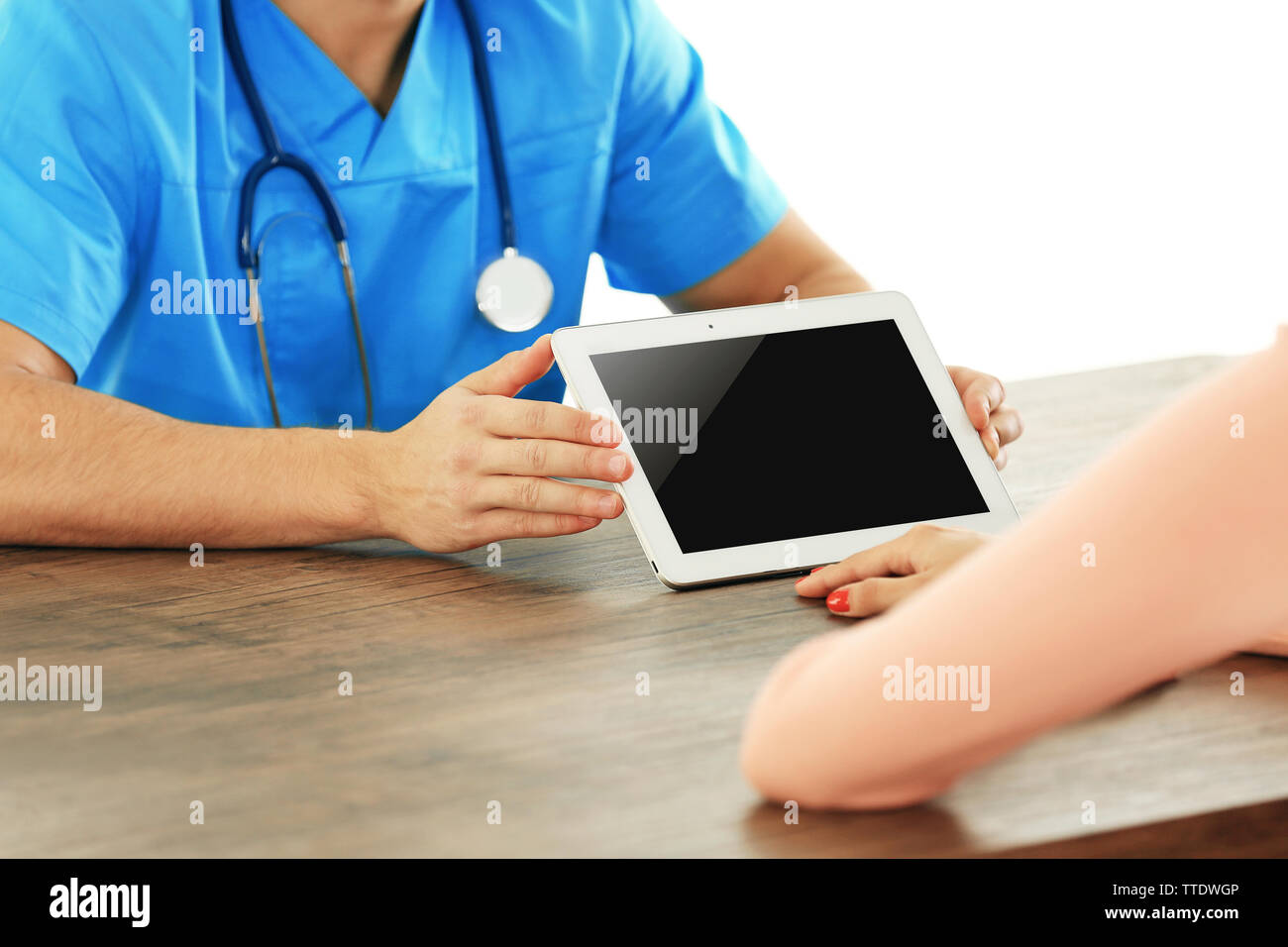 Male doctor with tablet and patient on light background Stock Photo - Alamy