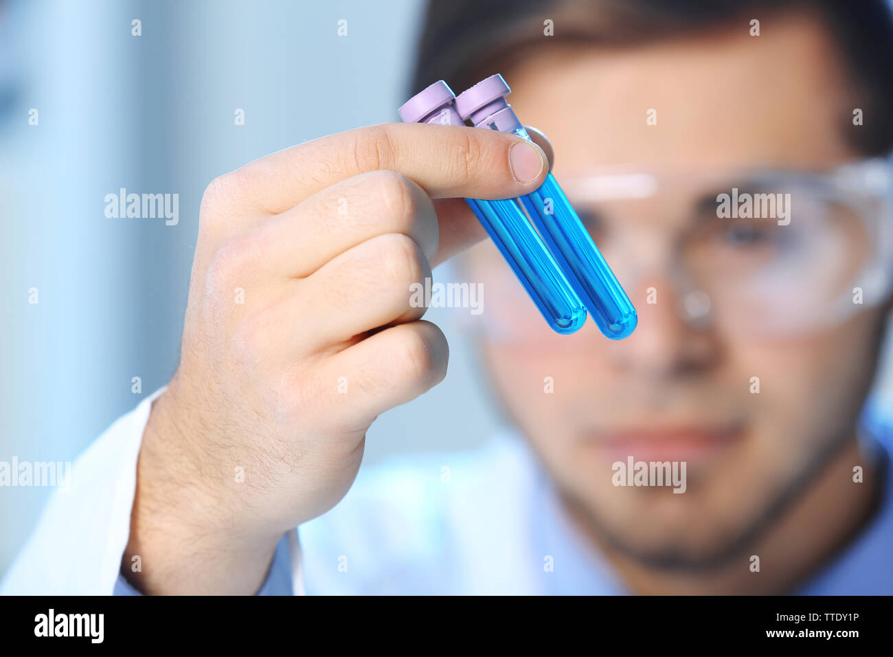Man in laboratory checking test tubes Stock Photo - Alamy