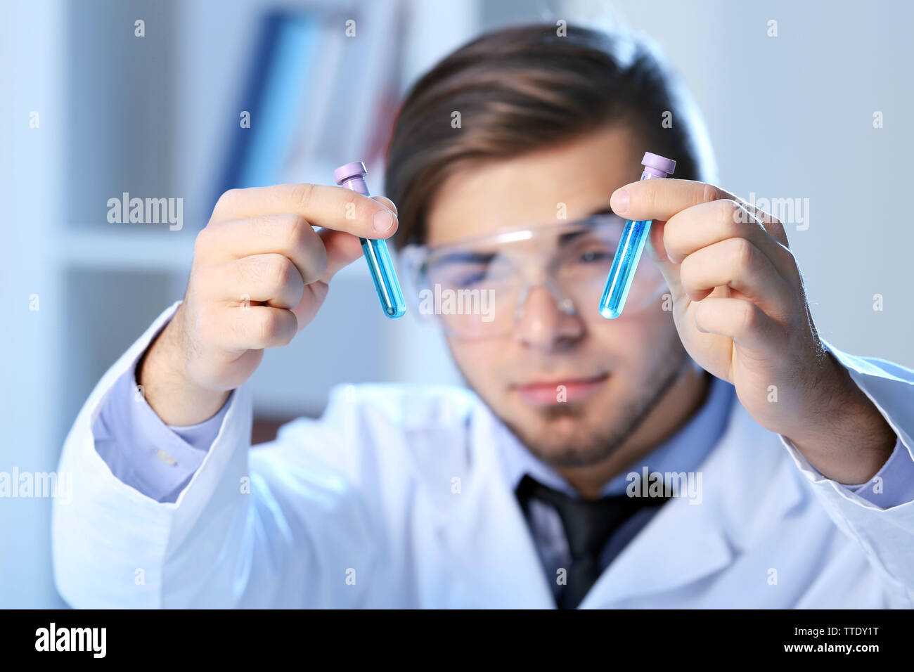 Man in laboratory checking test tubes Stock Photo - Alamy