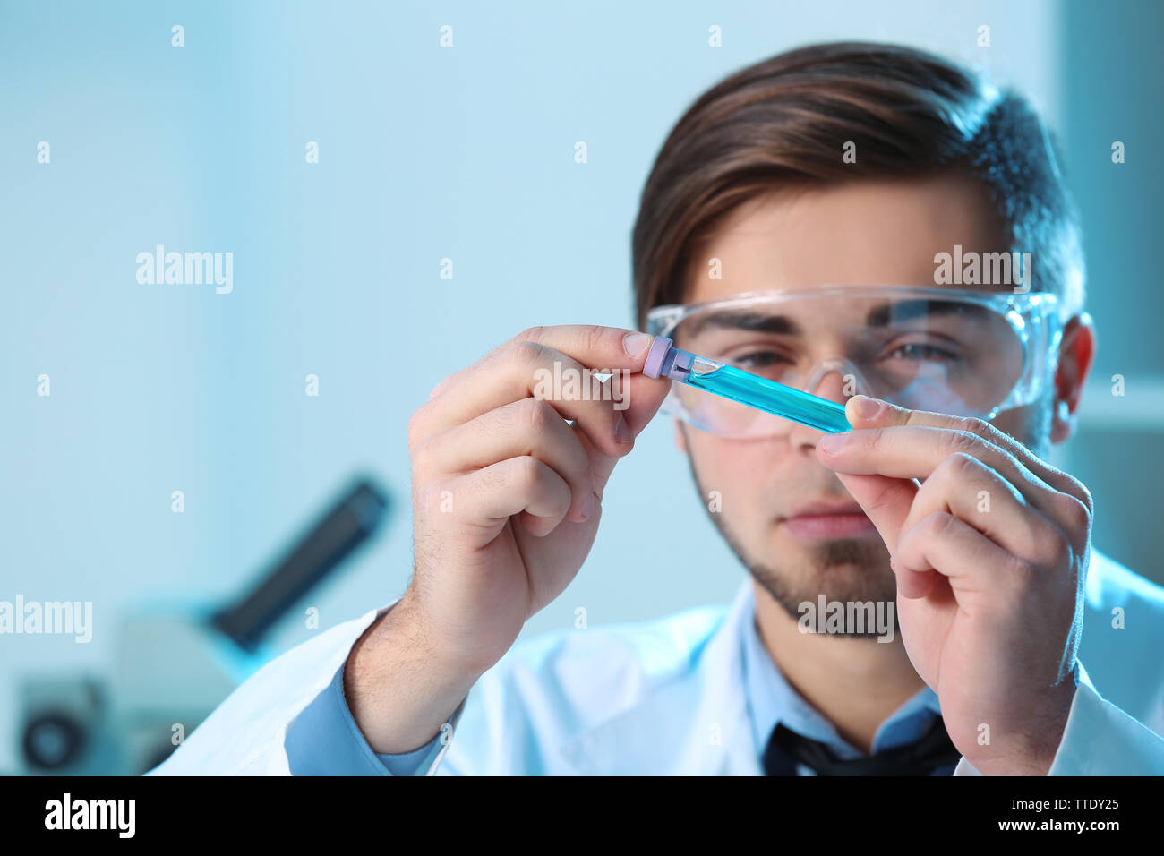Man in laboratory checking test tubes Stock Photo - Alamy