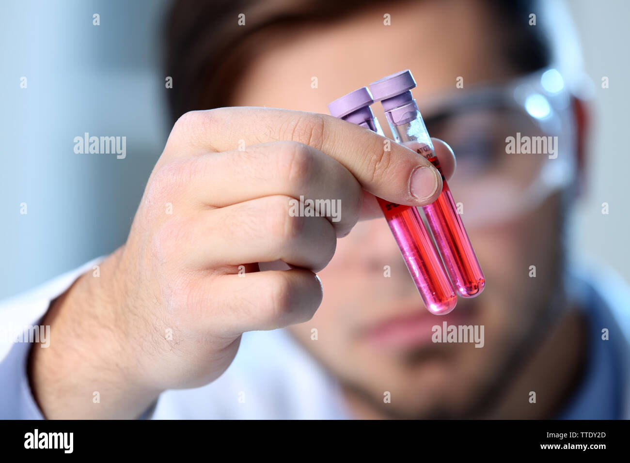 Man in laboratory checking test tubes Stock Photo - Alamy