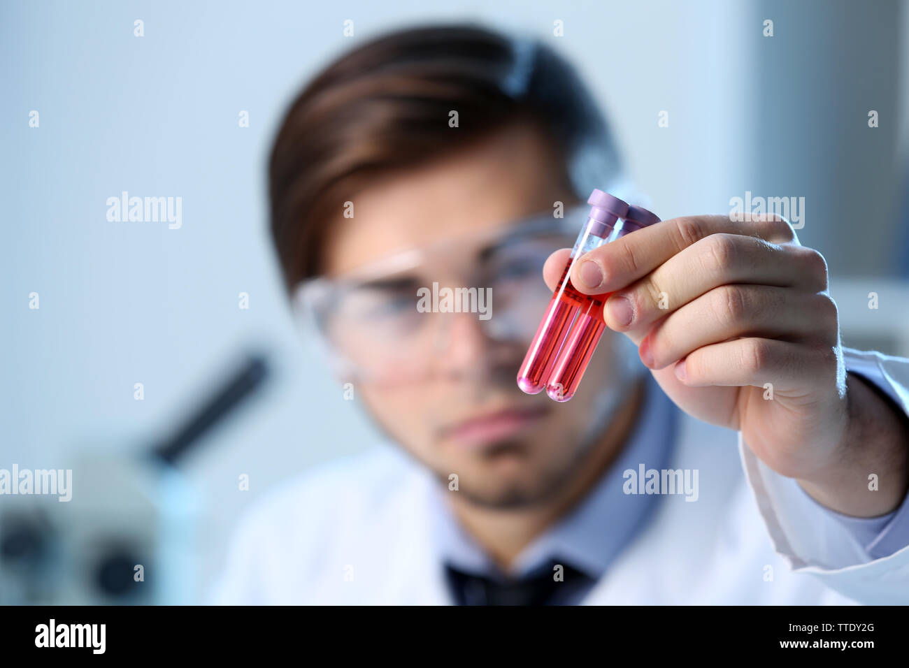 Man in laboratory checking test tubes Stock Photo - Alamy