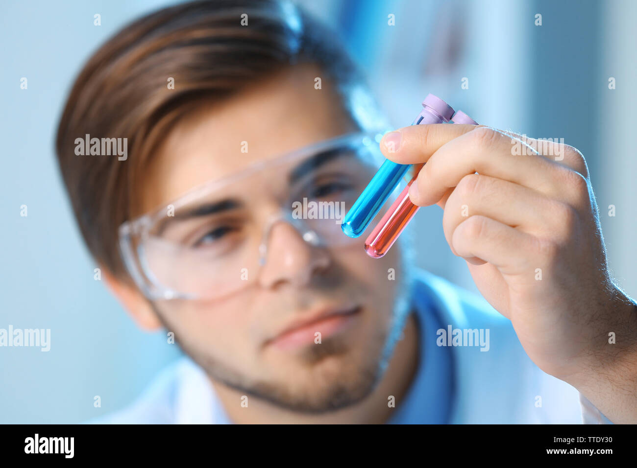 Man in laboratory checking test tubes Stock Photo - Alamy