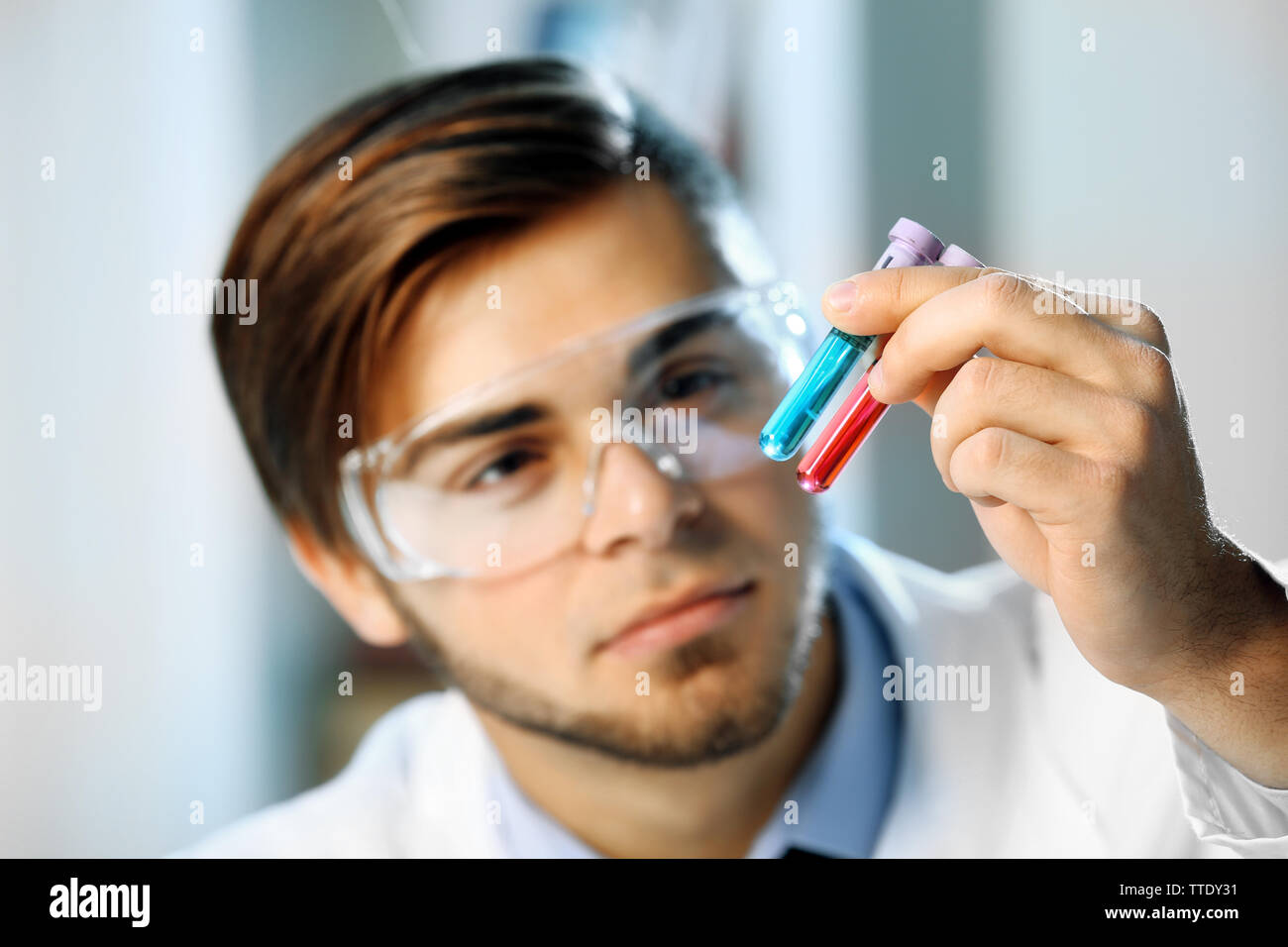 Man in laboratory checking test tubes Stock Photo - Alamy