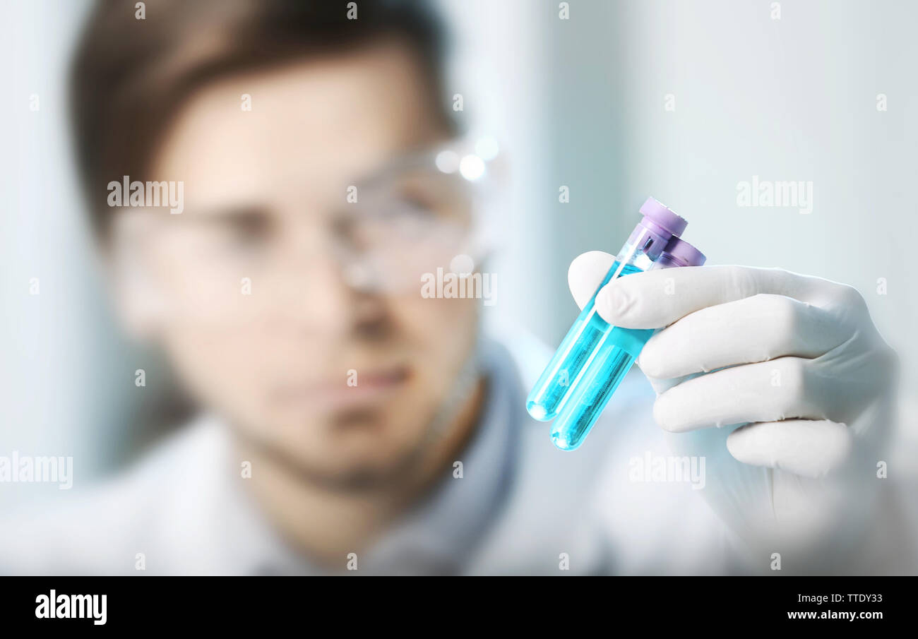 Man in laboratory checking test tubes Stock Photo - Alamy