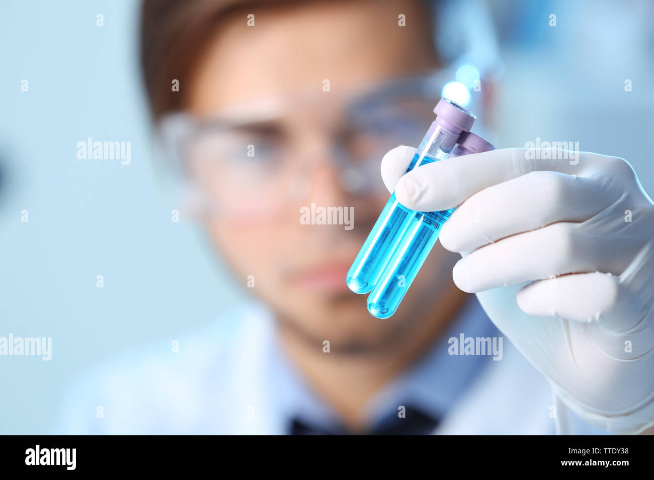 Man in laboratory checking test tubes Stock Photo - Alamy