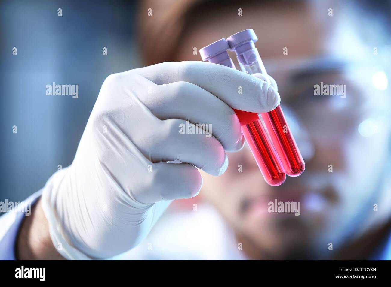 Man in laboratory checking test tubes Stock Photo - Alamy
