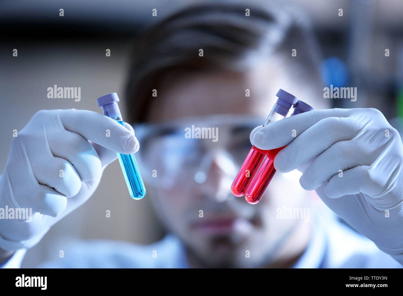 Man in laboratory checking test tubes Stock Photo - Alamy