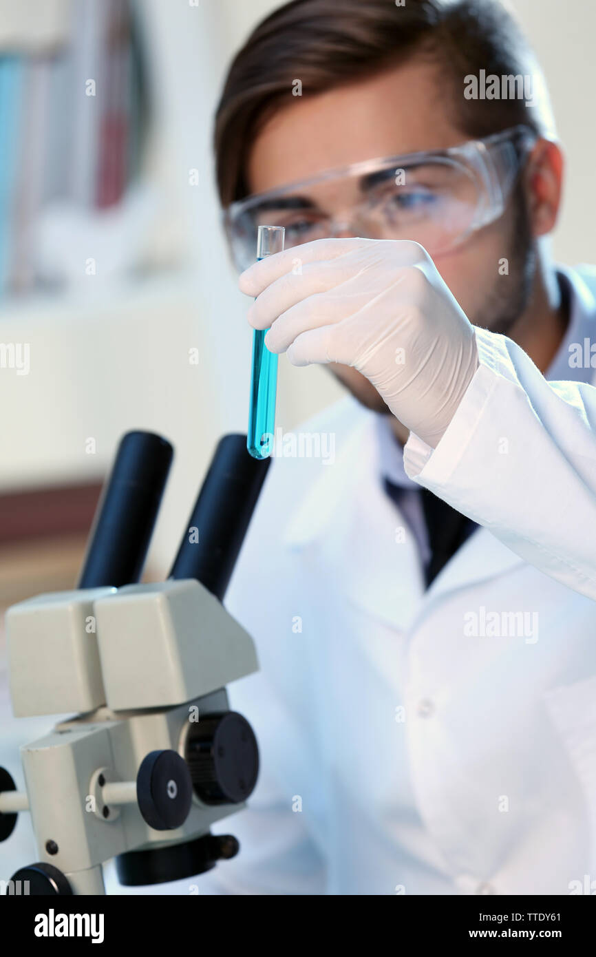 Serious clinician studying chemical element in laboratory Stock Photo ...