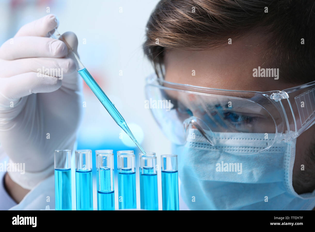 Man in laboratory checking test tubes Stock Photo - Alamy