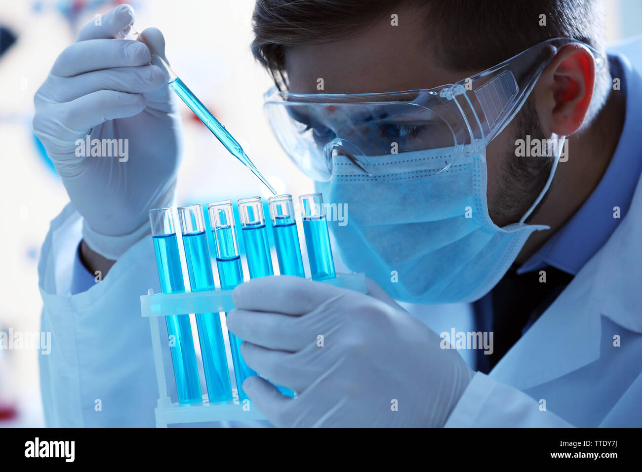 Man in laboratory checking test tubes Stock Photo - Alamy