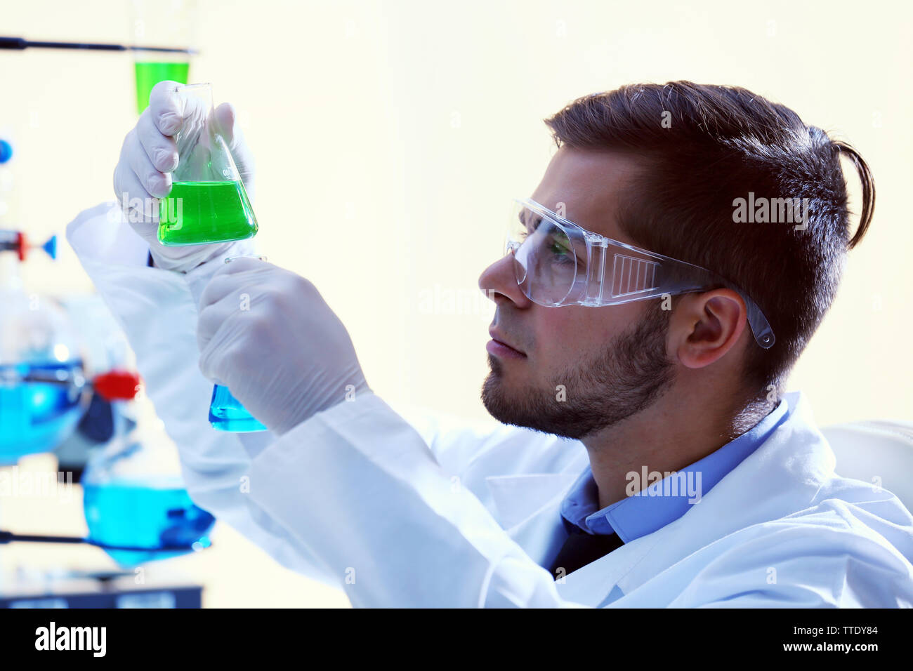 Man in laboratory checking test tubes Stock Photo - Alamy