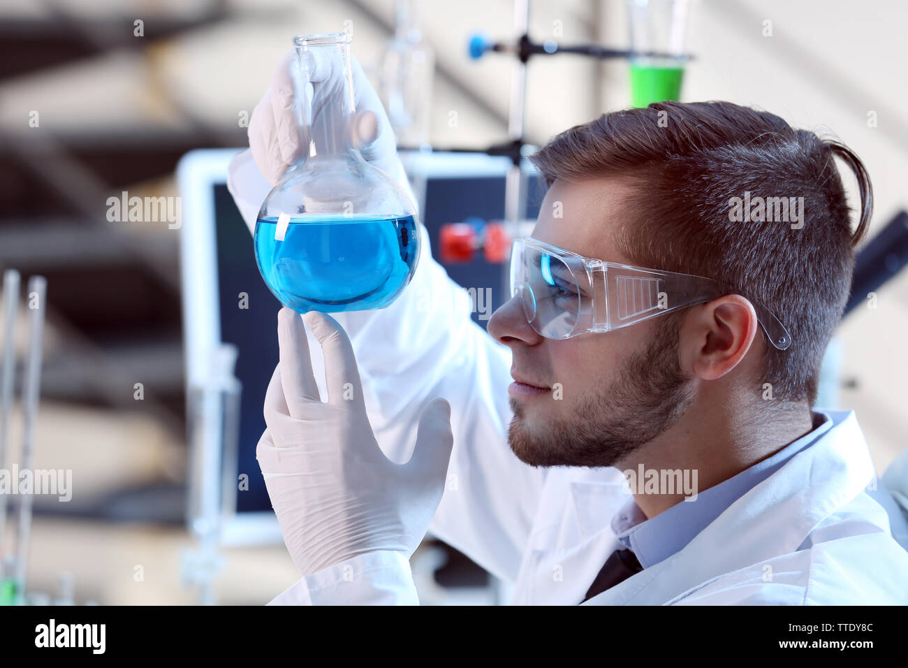 Man in laboratory checking test tubes Stock Photo - Alamy
