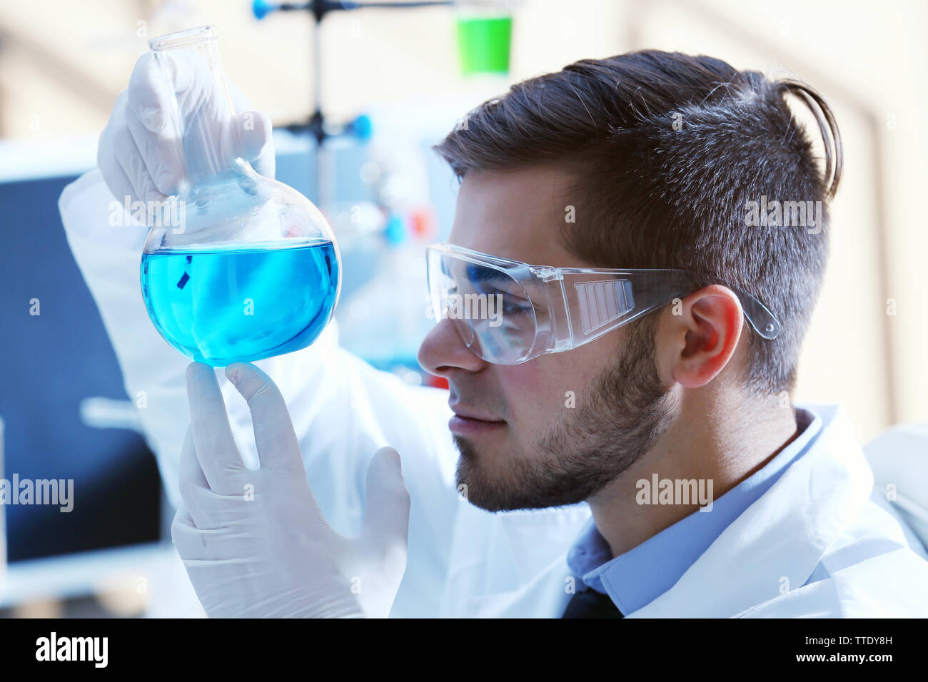 Man in laboratory checking test tubes Stock Photo - Alamy