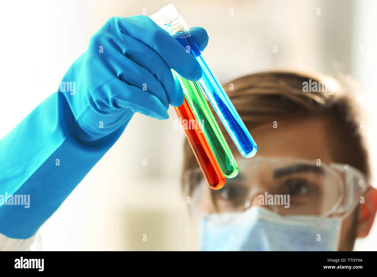 Man in laboratory checking test tubes Stock Photo - Alamy