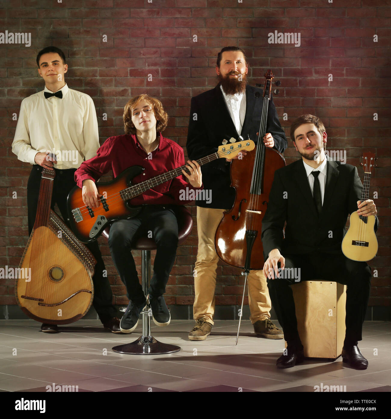 Man's musical band on brick wall background in the studio Stock Photo ...