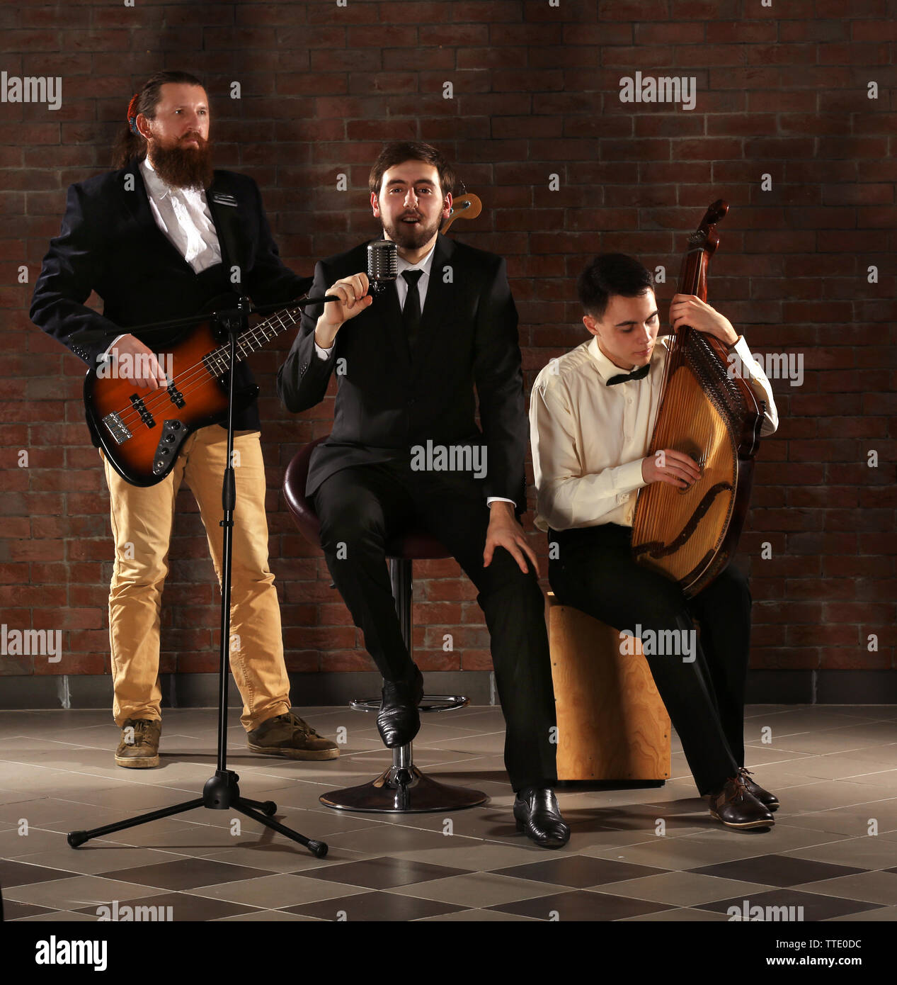 Man's musical band on brick wall background in the studio Stock Photo ...