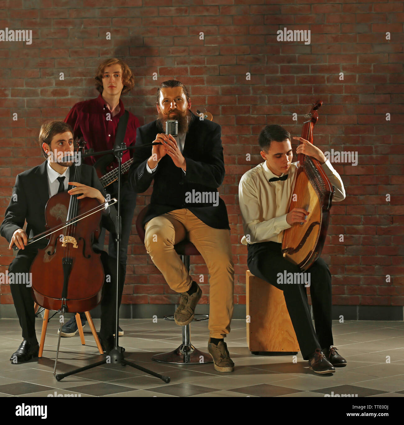 Man's musical band on brick wall background in the studio Stock Photo ...