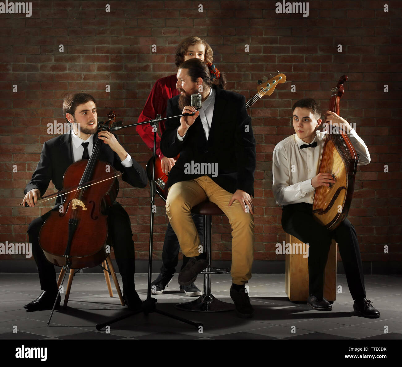 Man's musical band on brick wall background in the studio Stock Photo ...